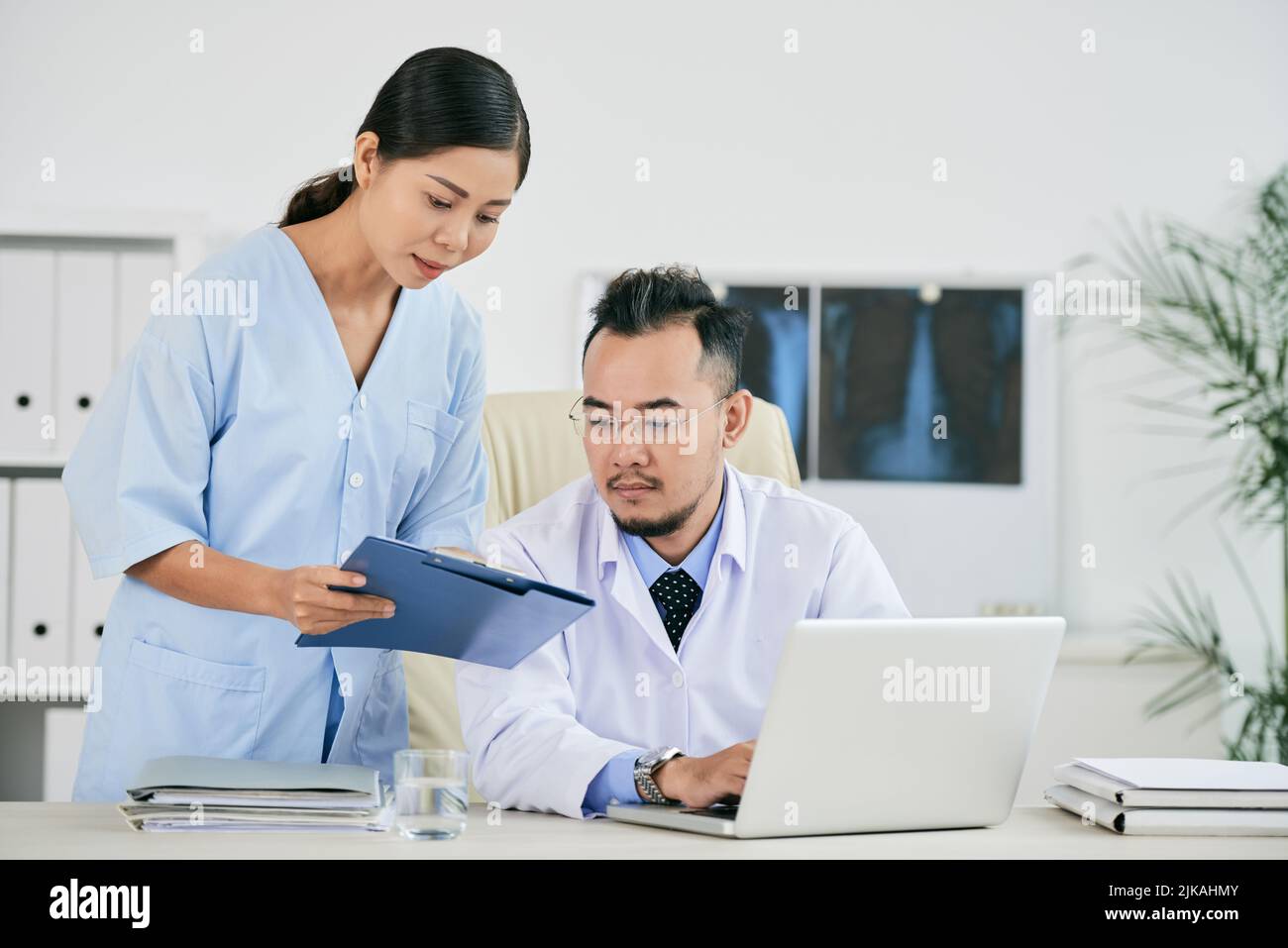 Nurse showing medical history to general practitioner Stock Photo - Alamy