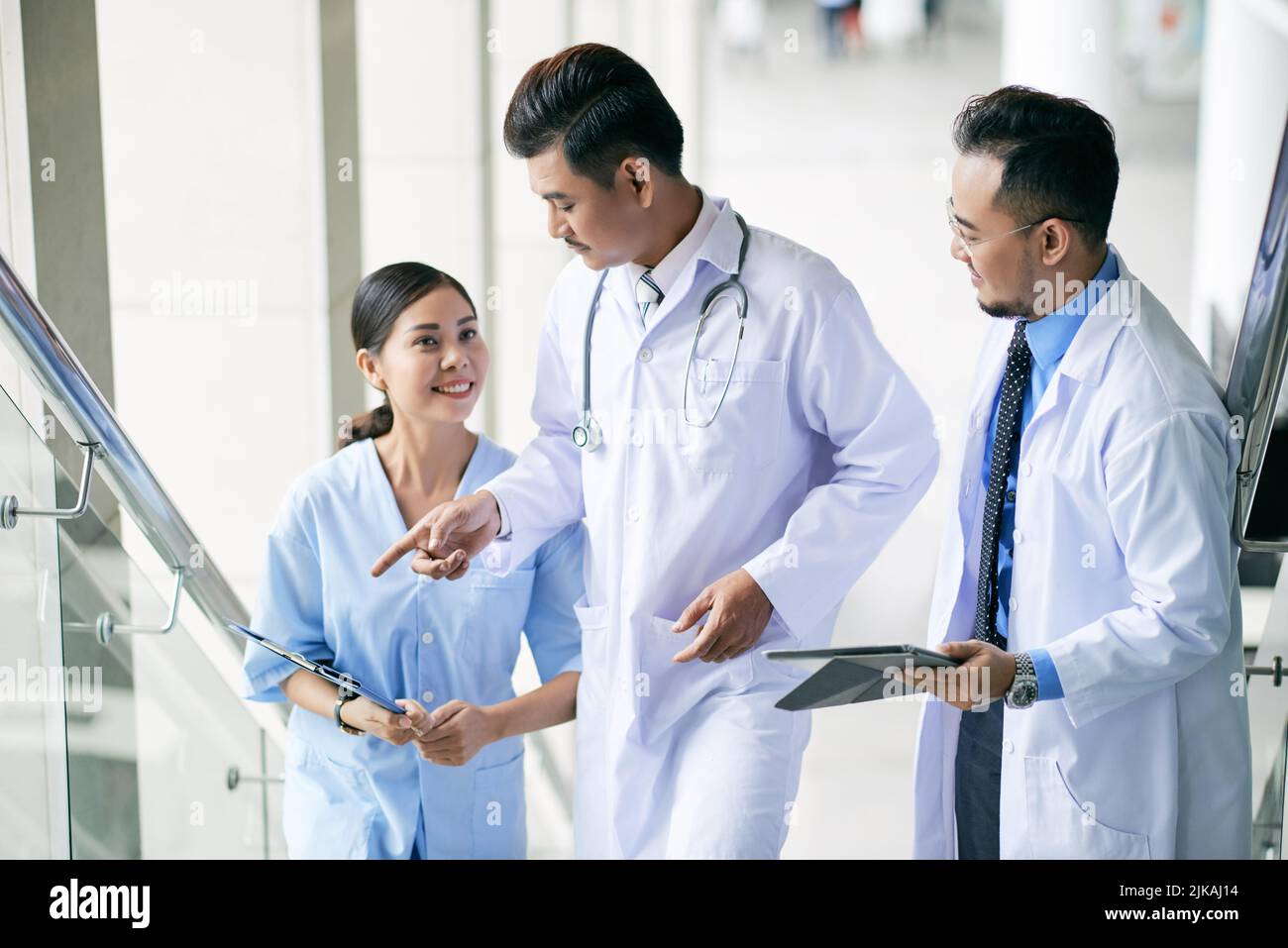 Doctor giving instructions to young interns when they are walking up the stairs Stock Photo - Alamy