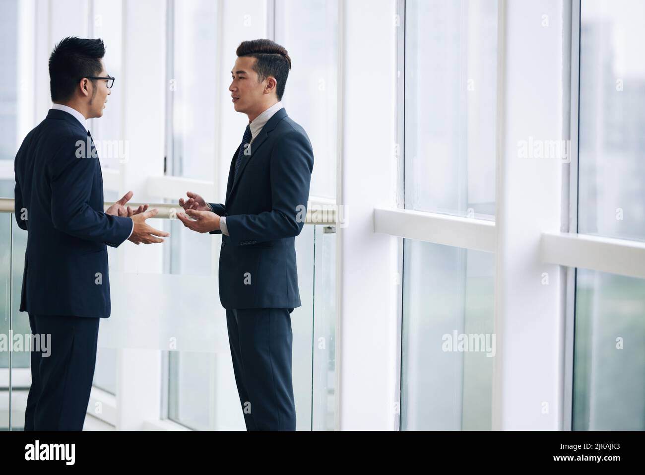 Vietnamese business people talking in office corridor Stock Photo - Alamy