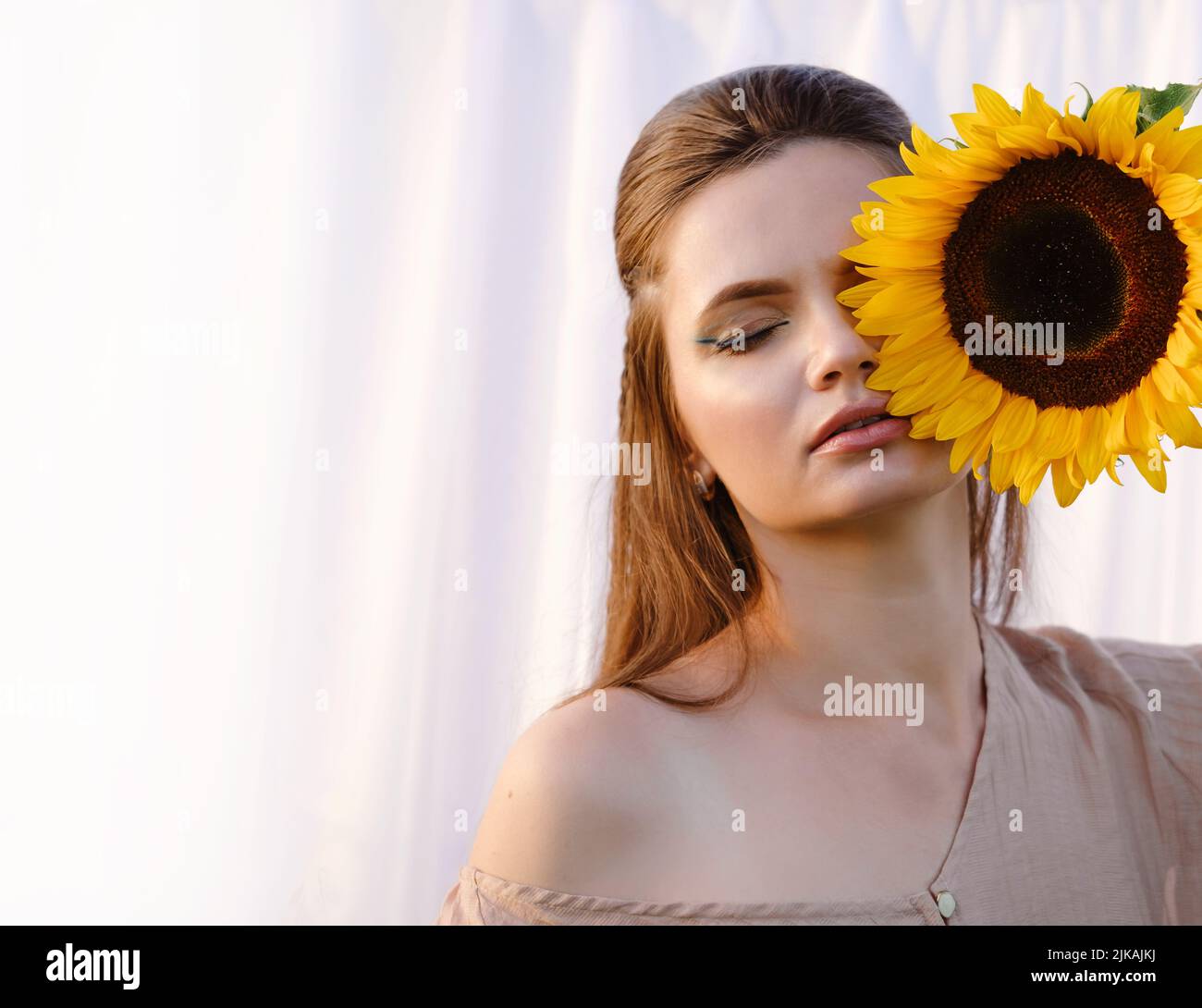 Romantic woman with sunflowers over white fabric background. Clean skin ...