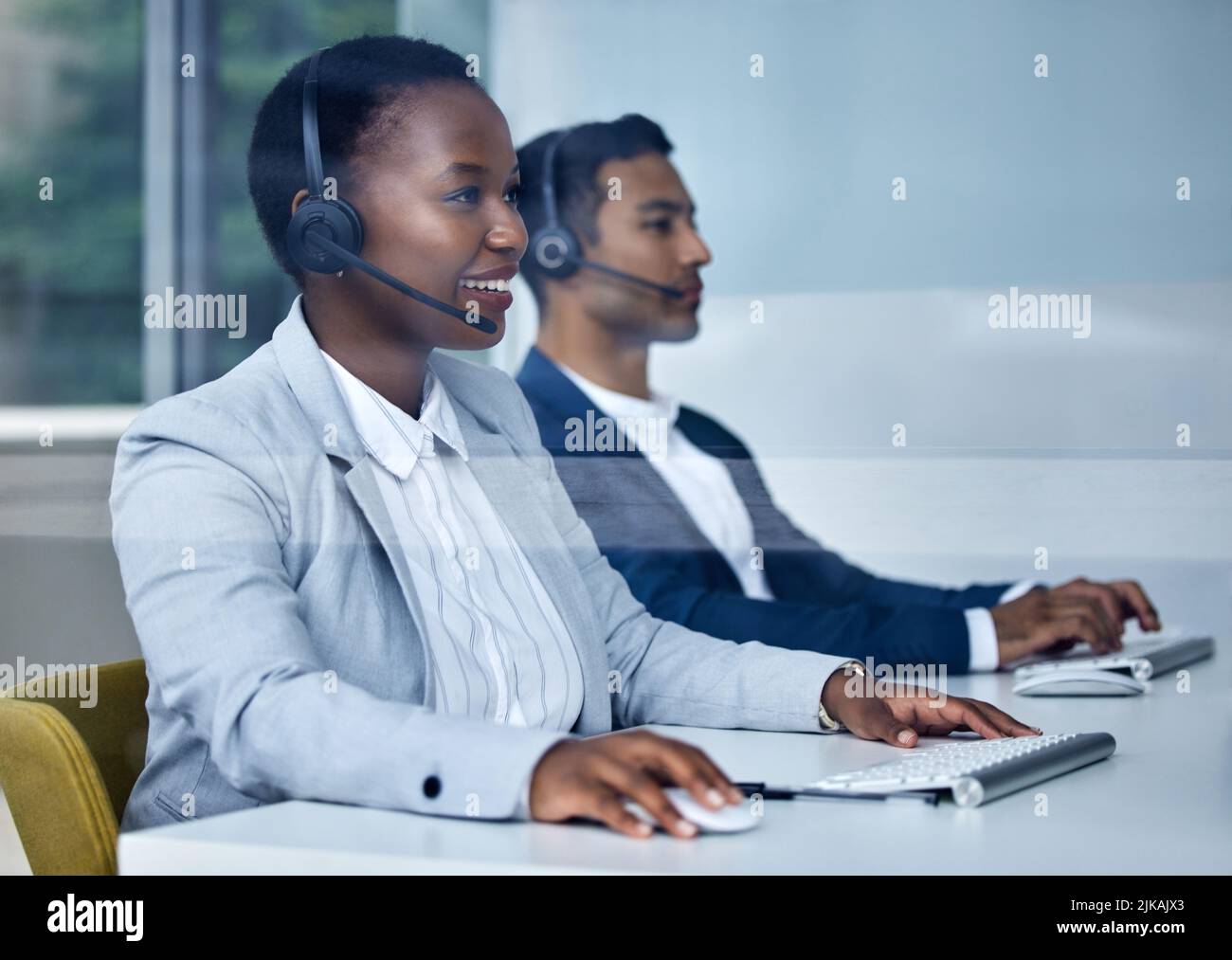 Helping customers one call at a time. two young call center agents ...