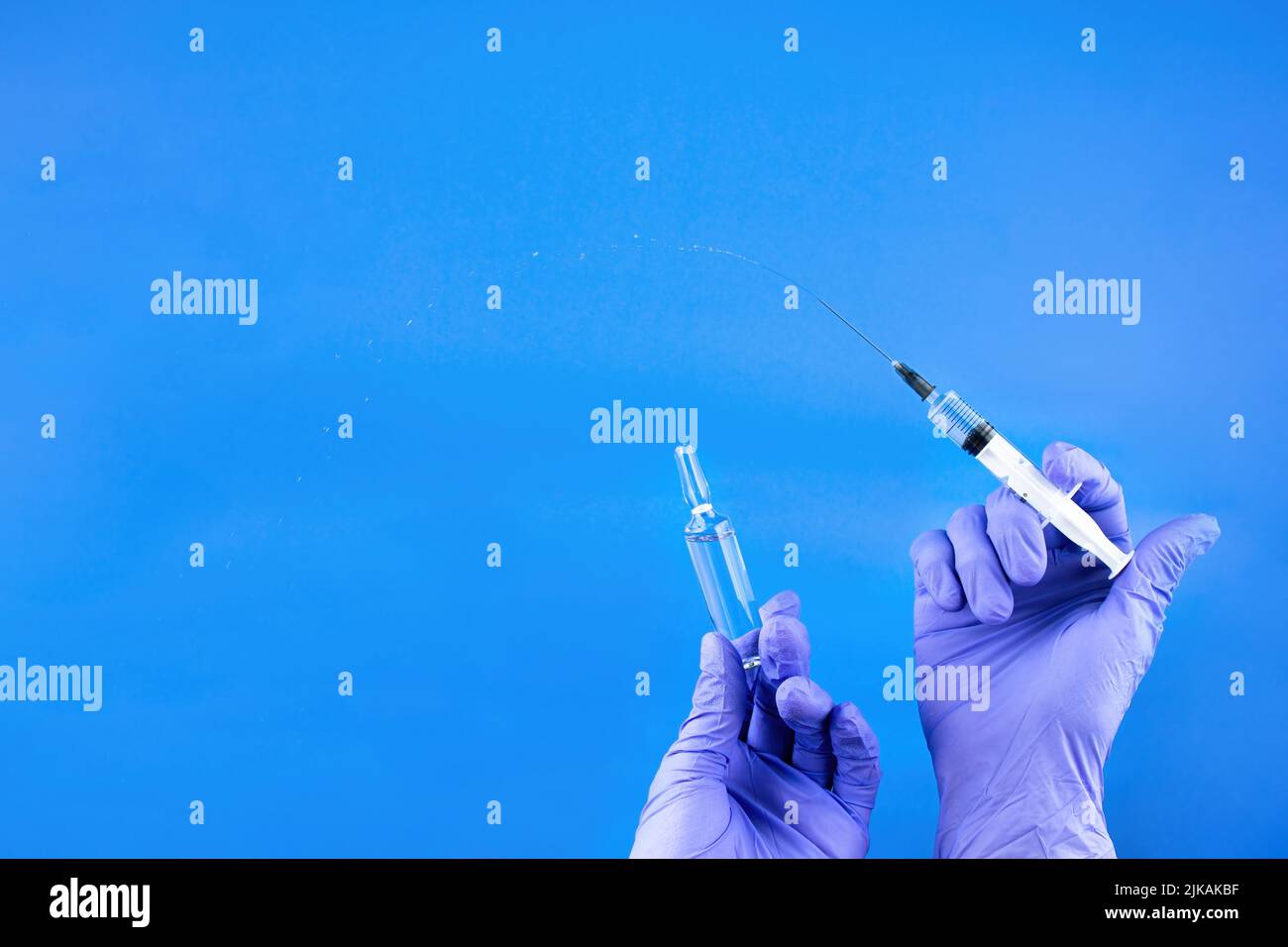 a disposable syringe with a transparent needle and an ampoule of liquid ...
