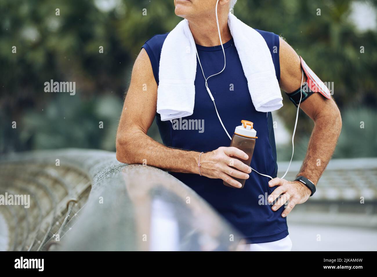 Cropped image of senior jogger with bottle of water Stock Photo - Alamy