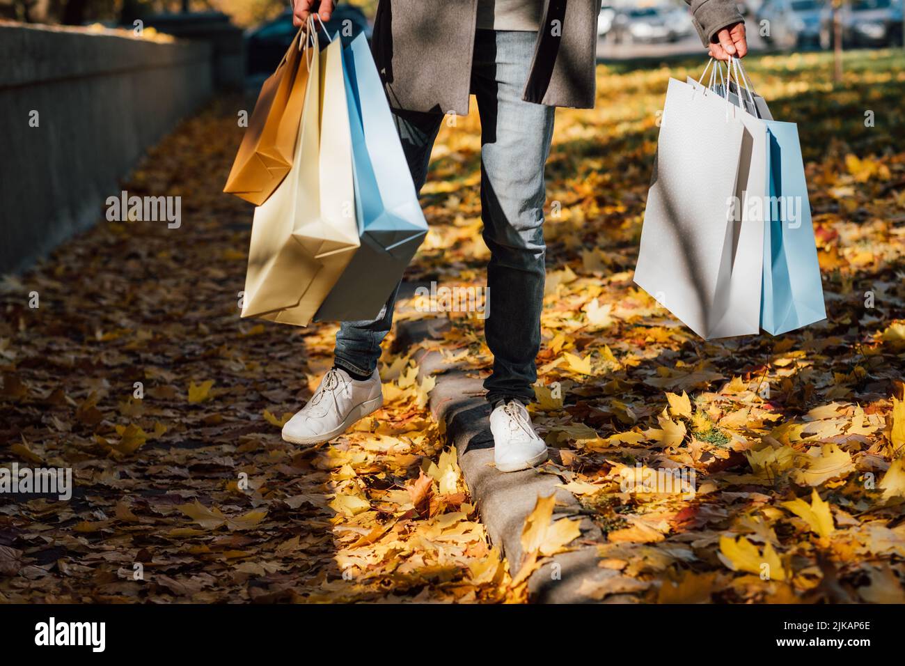 autumn fun man shopping bags fall leaves sidewalk Stock Photo - Alamy