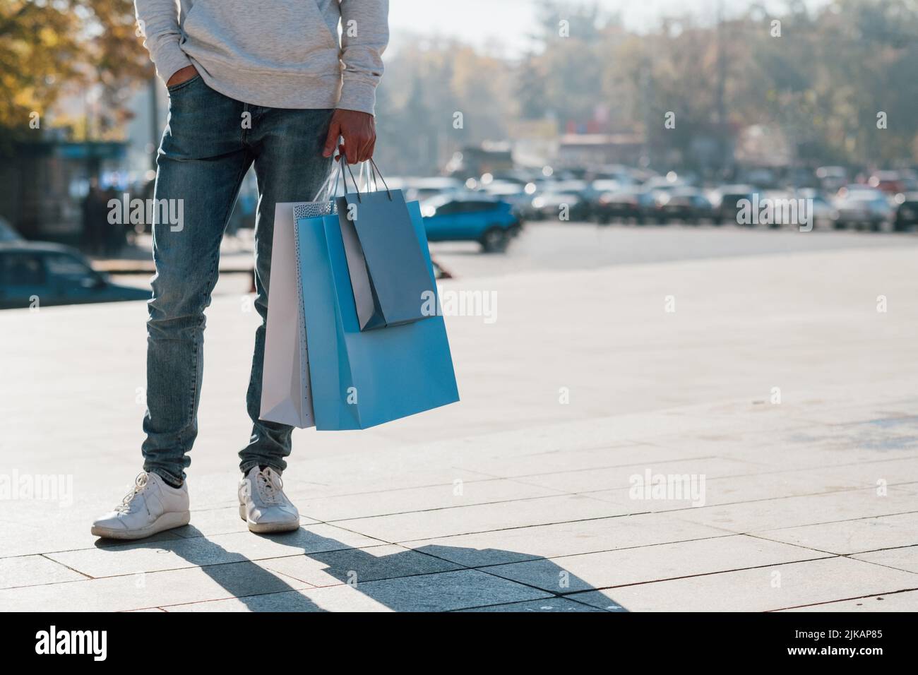 shopaholic lifestyle man package fall urban street Stock Photo - Alamy