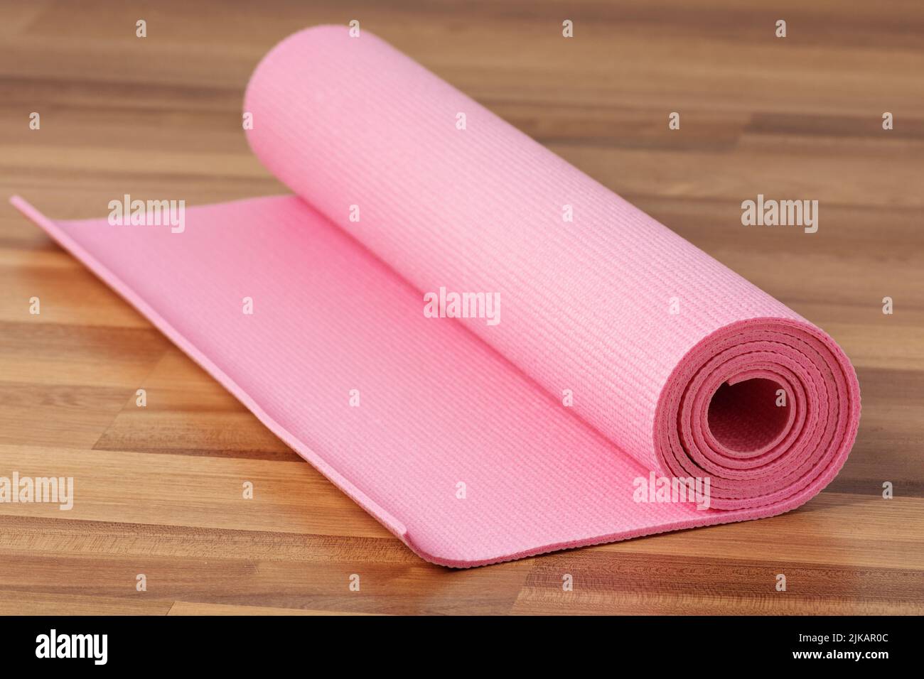 Pink exercise mat on wooden floor. Home workout concept Stock Photo - Alamy