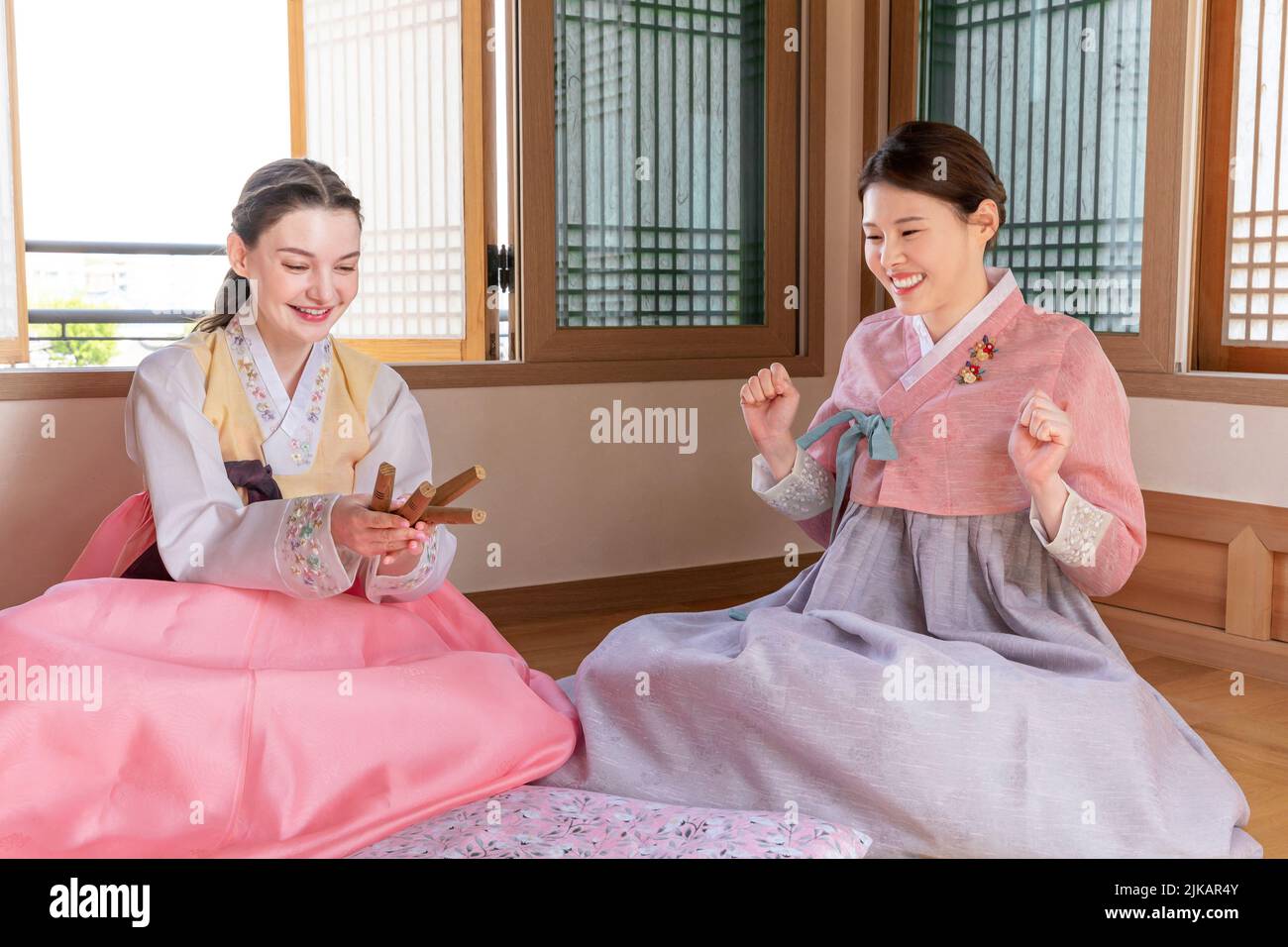 Korean and Caucasian girls wearing Hanbok playing Yut, Korean ...