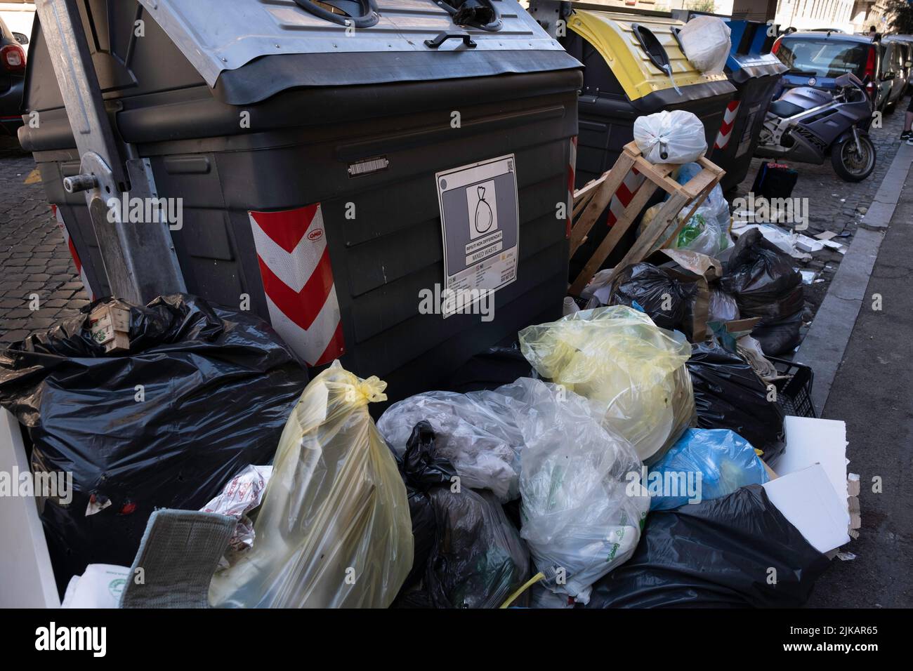 Overflowing dumpsters and garbage bags on the edge of a street in Rome ...