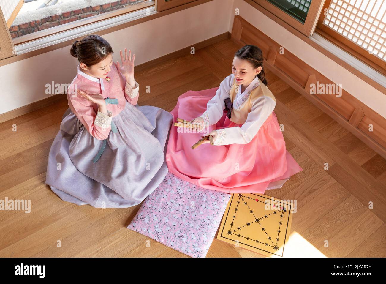 Korean and Caucasian girls wearing Hanbok playing Yut, Korean ...