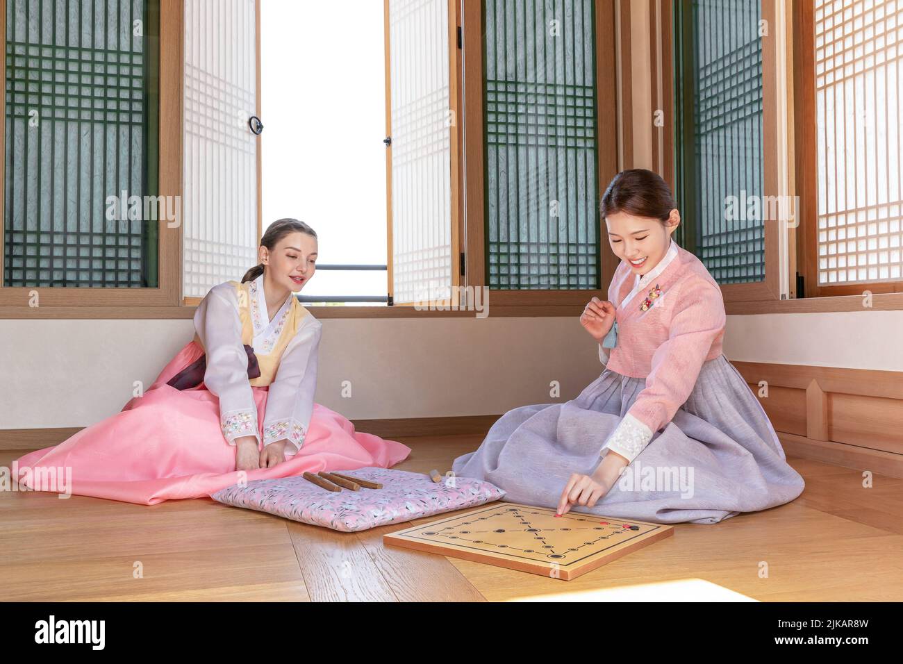 Korean and Caucasian girls wearing Hanbok playing Yut, Korean ...