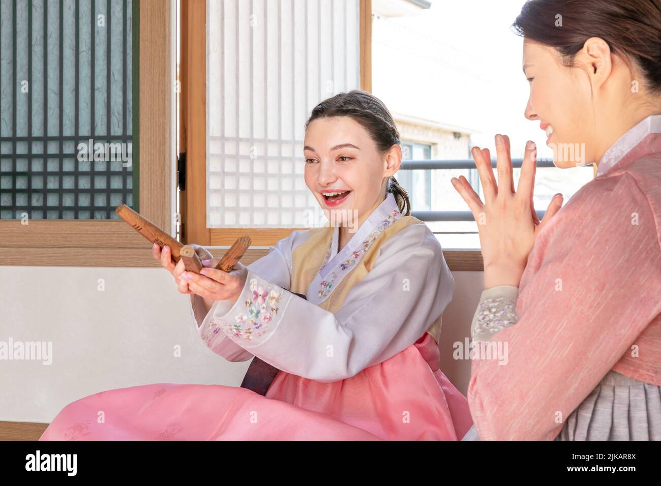 Korean and Caucasian girls wearing Hanbok playing Yut, Korean ...