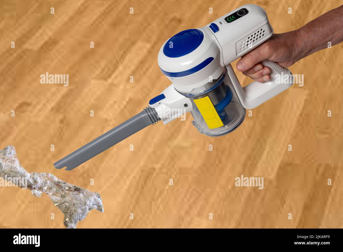 The male hand holds hold a modern cordless battery-powered vacuum ...