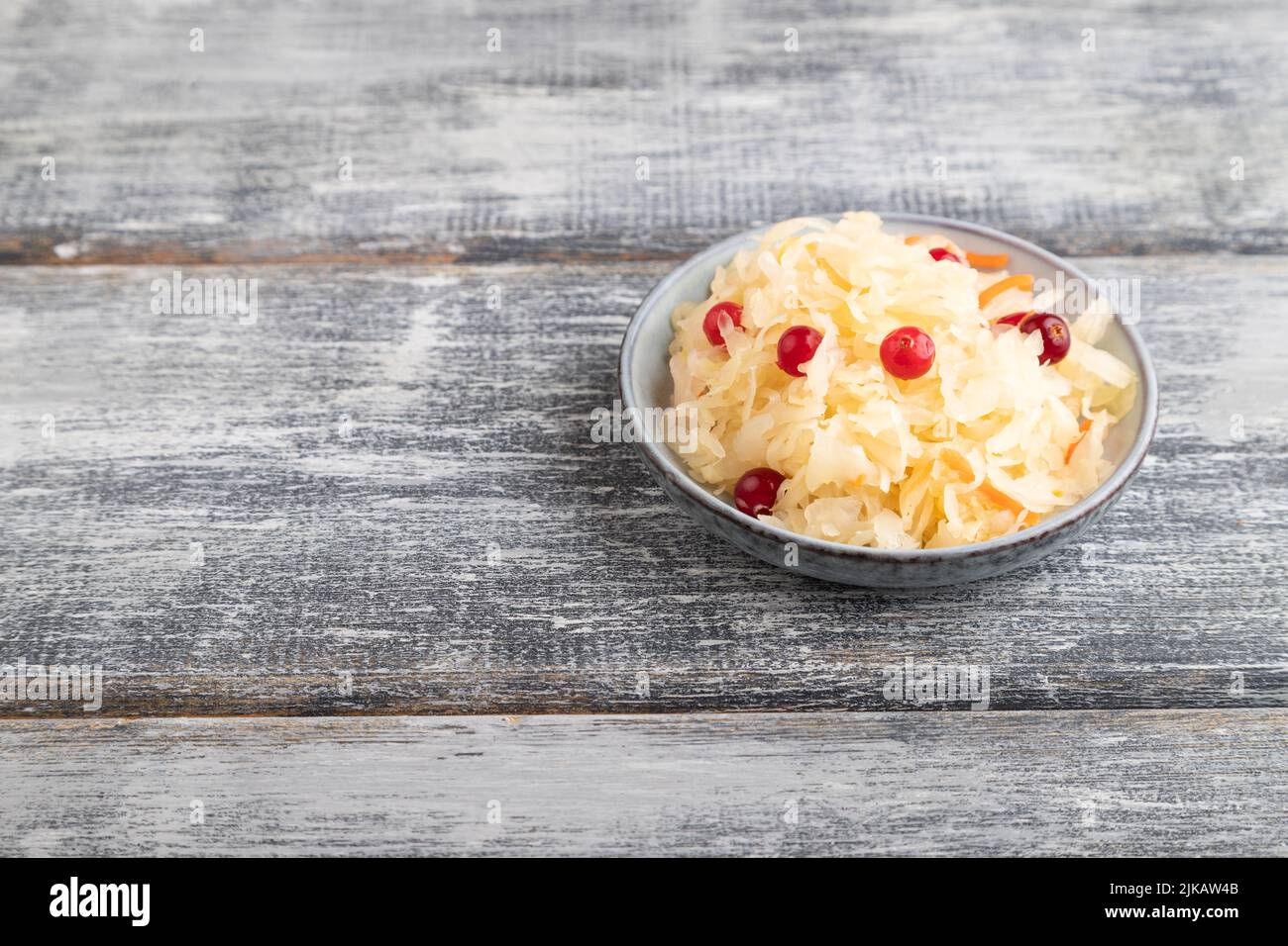 sauerkraut, marinated cabbage on a blue ceramic plate on a gray wooden ...