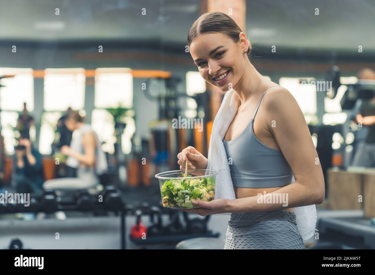 Young happy girl eating healthy food and resting after exercises. High ...