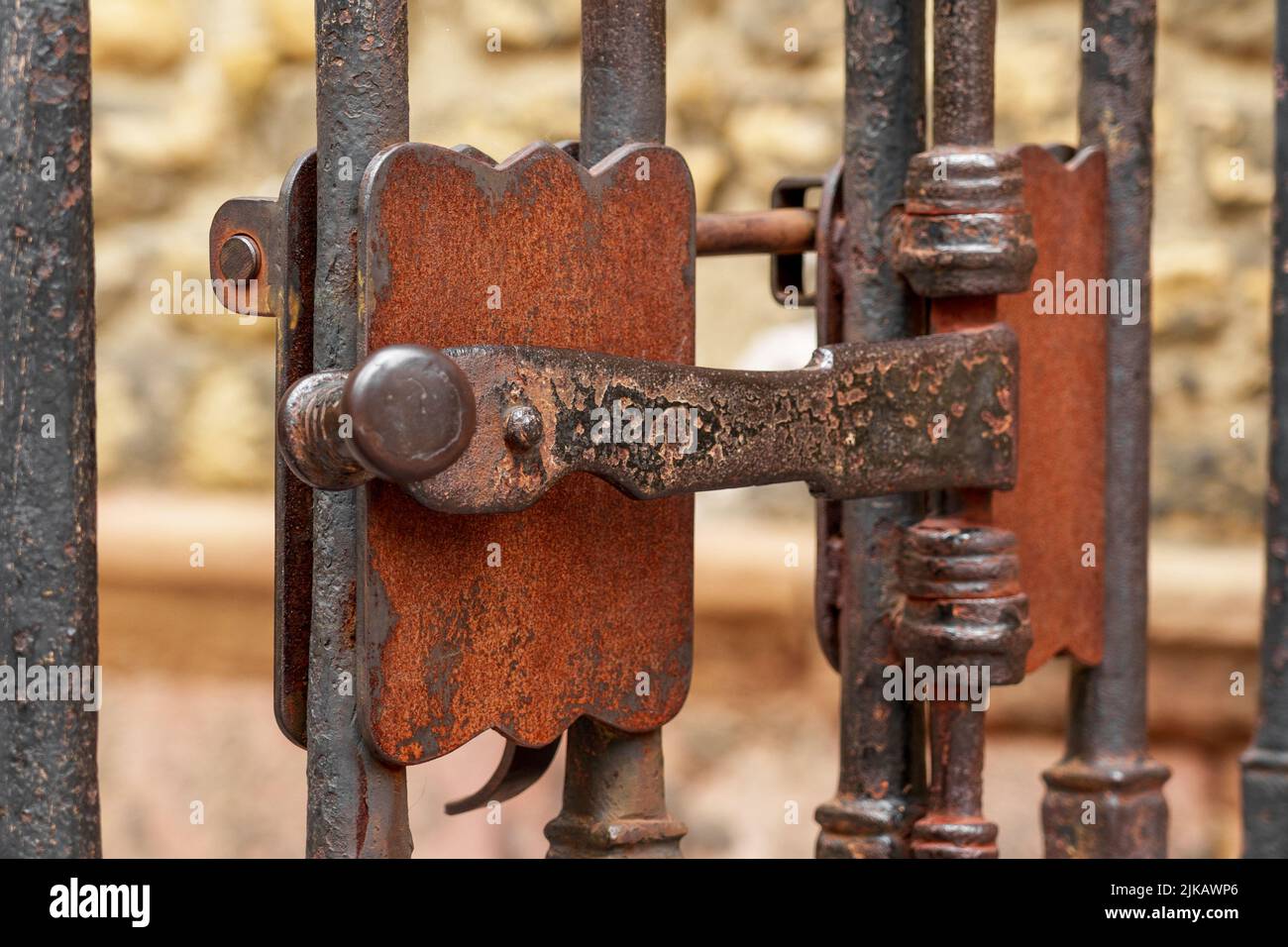 Antique iron wrought rusty latch of a locked medieval lattice gate ...