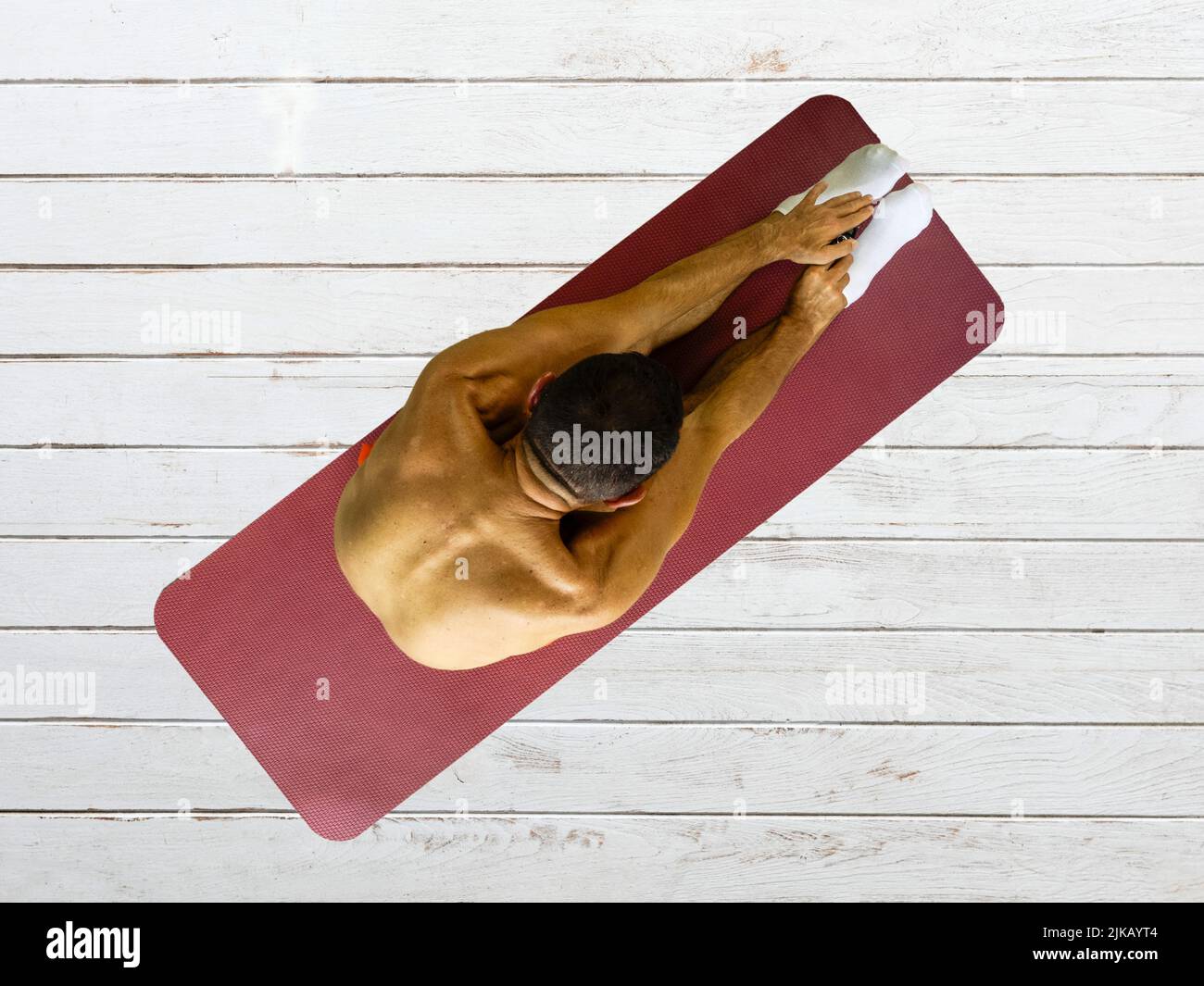 gymnastics, a man exercises his abdominal muscles on a mat, home ...