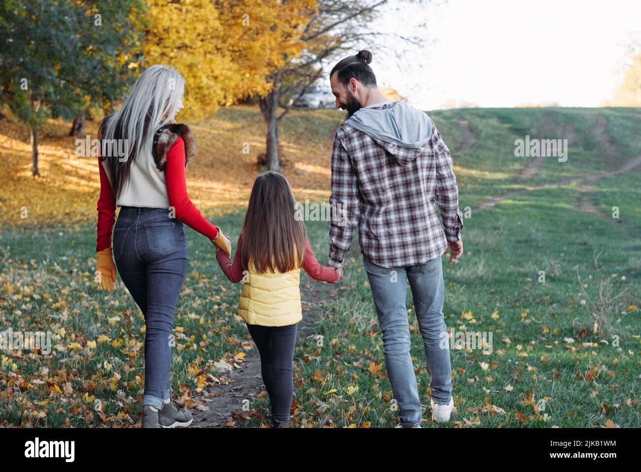 fall leisure parents daughter walking leaves Stock Photo - Alamy