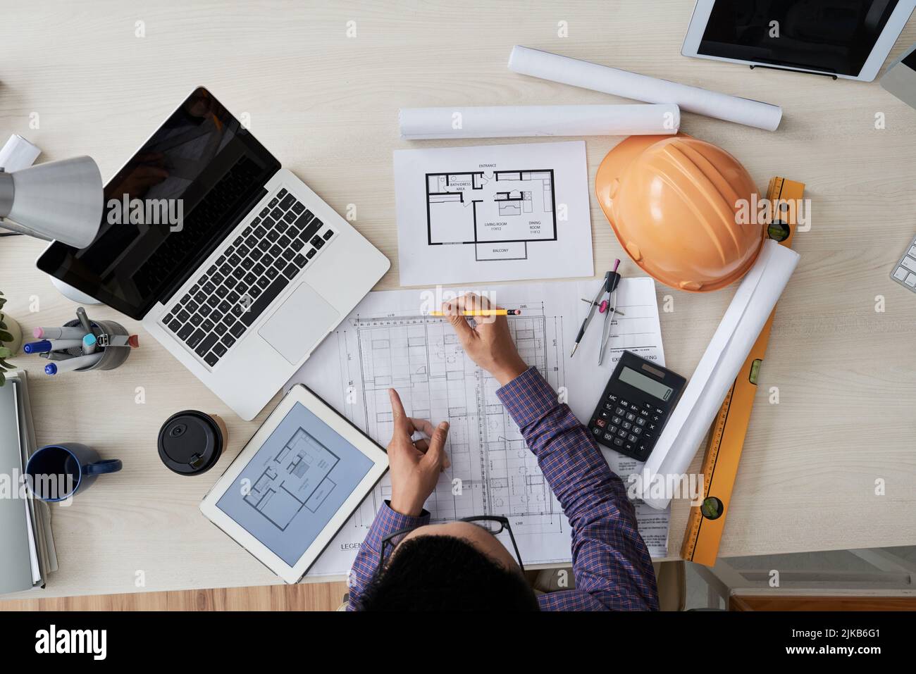 Engineer working on blueprint of the building for new district, view ...
