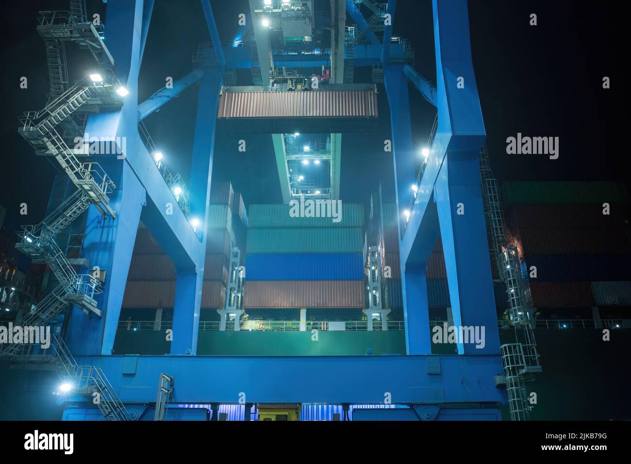 operation of container terminal at night. Unloading container ship at ...