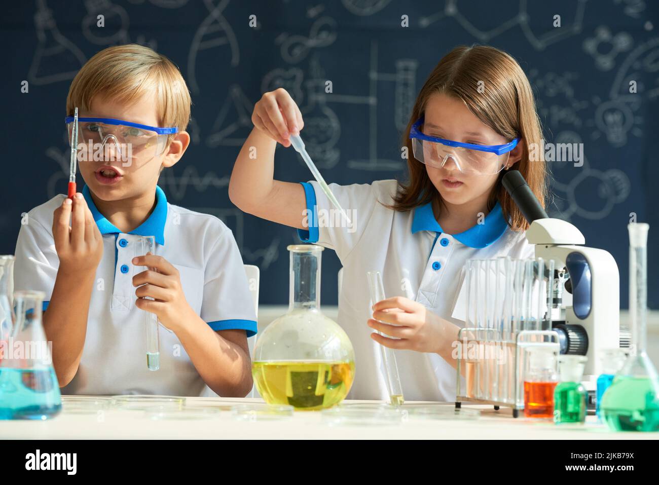 Smart children conducting experiment at chemistry class Stock Photo - Alamy