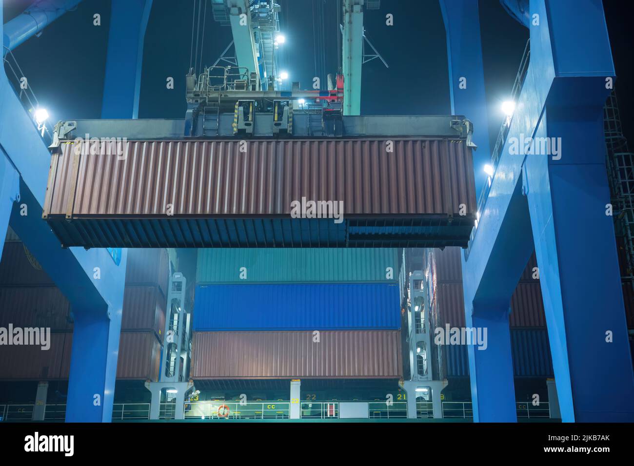 operation of container terminal at night. Unloading container ship at night. Mooring cranes ...