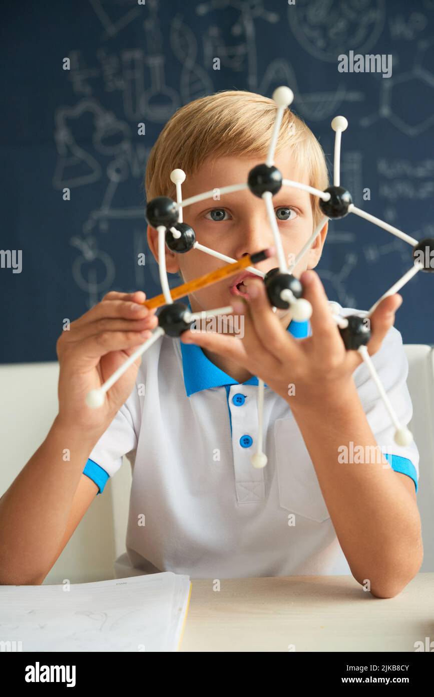 Smart school child holding plastic molecular model Stock Photo - Alamy