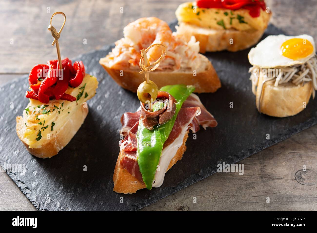 Assortment of Spanish pintxos on wooden table Stock Photo - Alamy