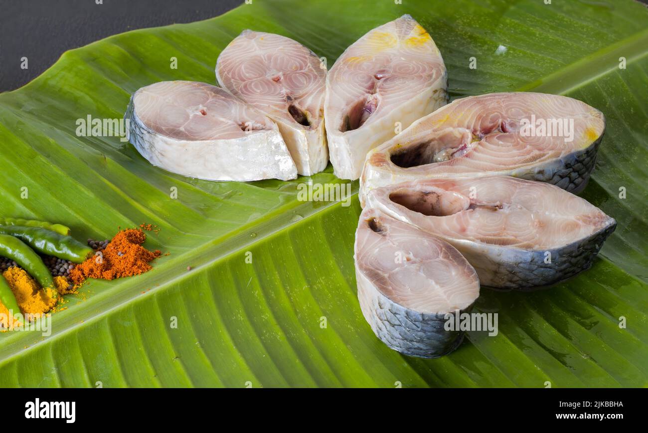 Raw hilsa fish cut into pieces kept on banana leaf for cooking. Shot ...