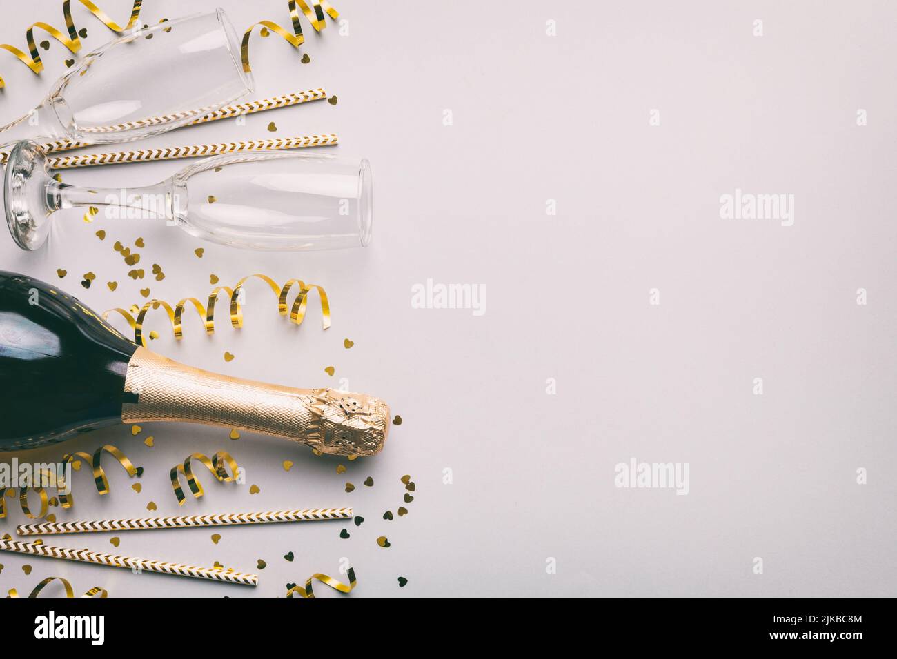 Champagne bottle, glitter and straws on color background. top view ...