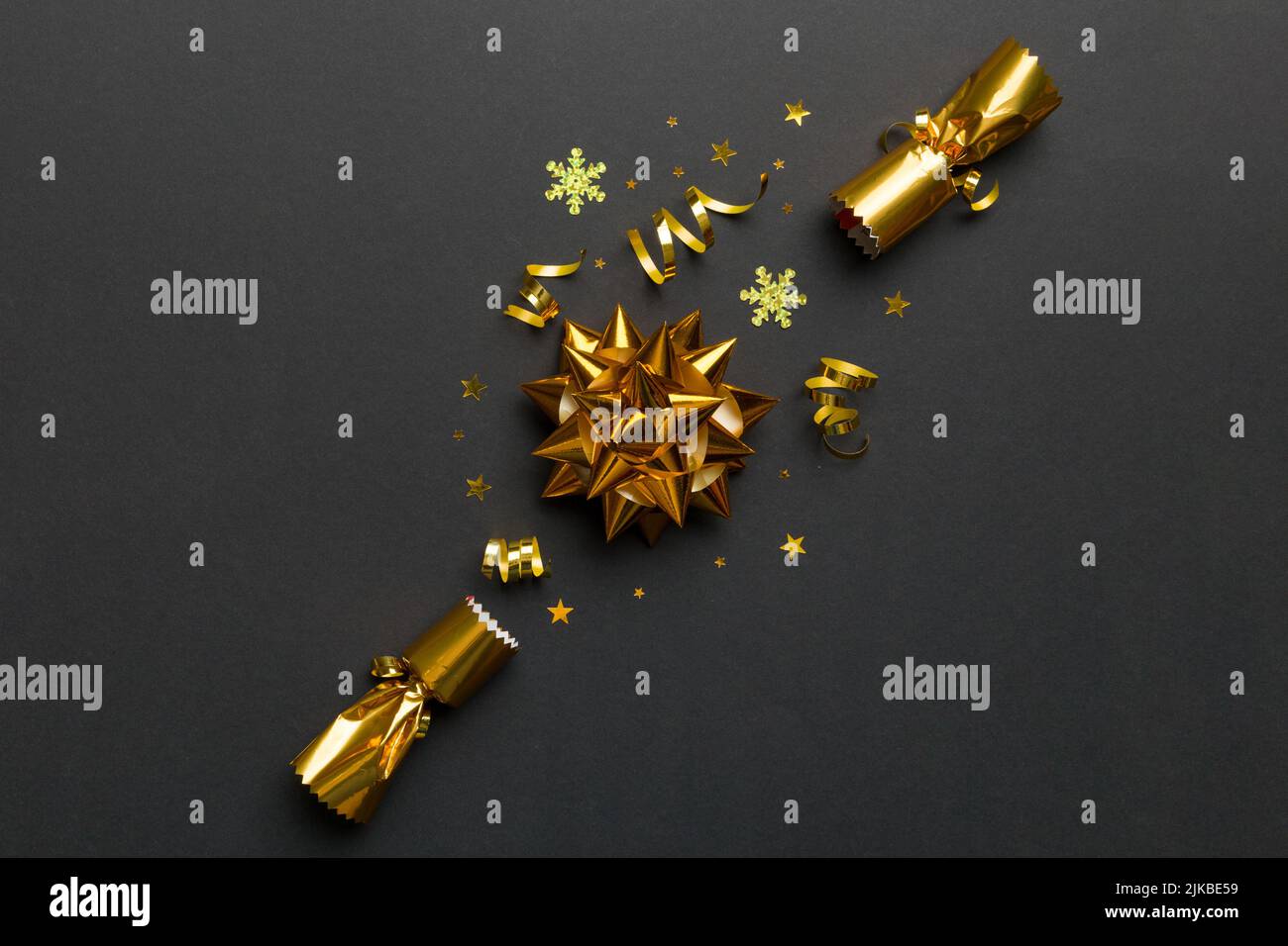 Christmas crackers with shiny confetti on color background, top view ...