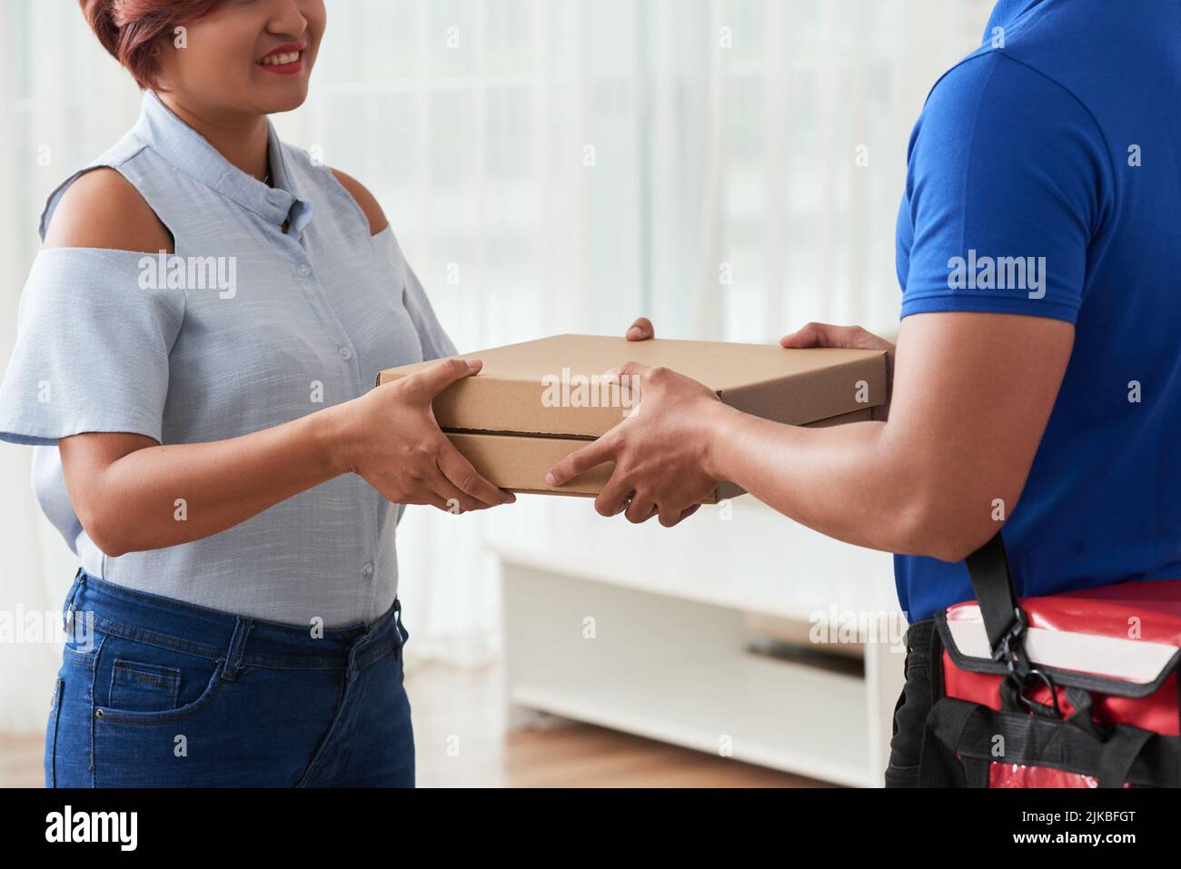 Cropped image of delivery man giving order to client Stock Photo - Alamy