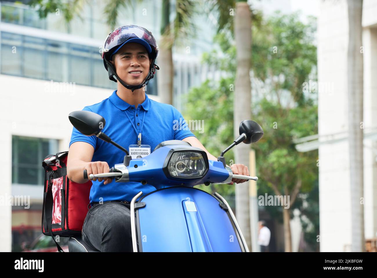 Vietnamese delivery man in helmet riding on scooter Stock Photo - Alamy