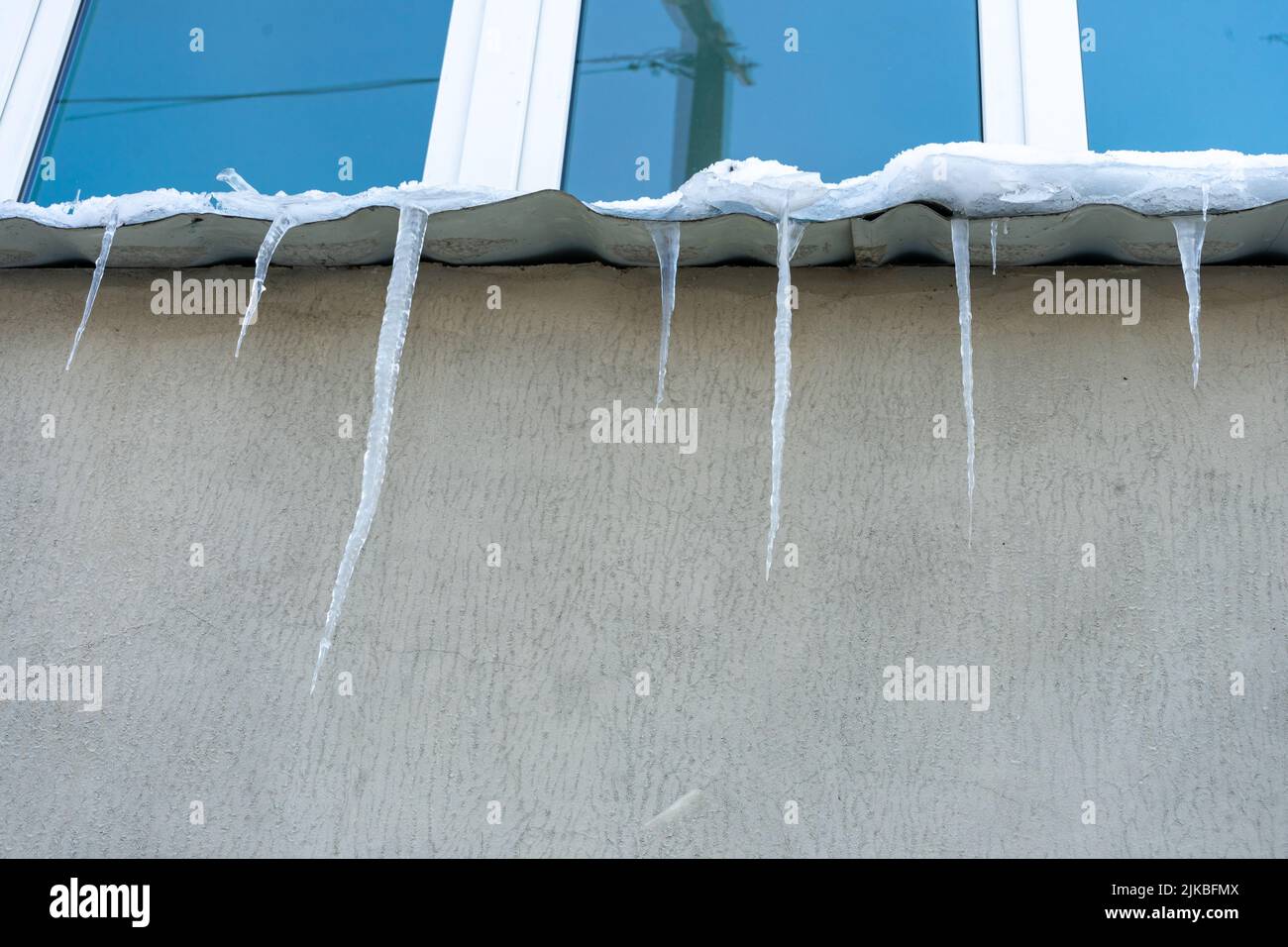 Ice icicles on the windowsill with a white plastic window Stock Photo ...