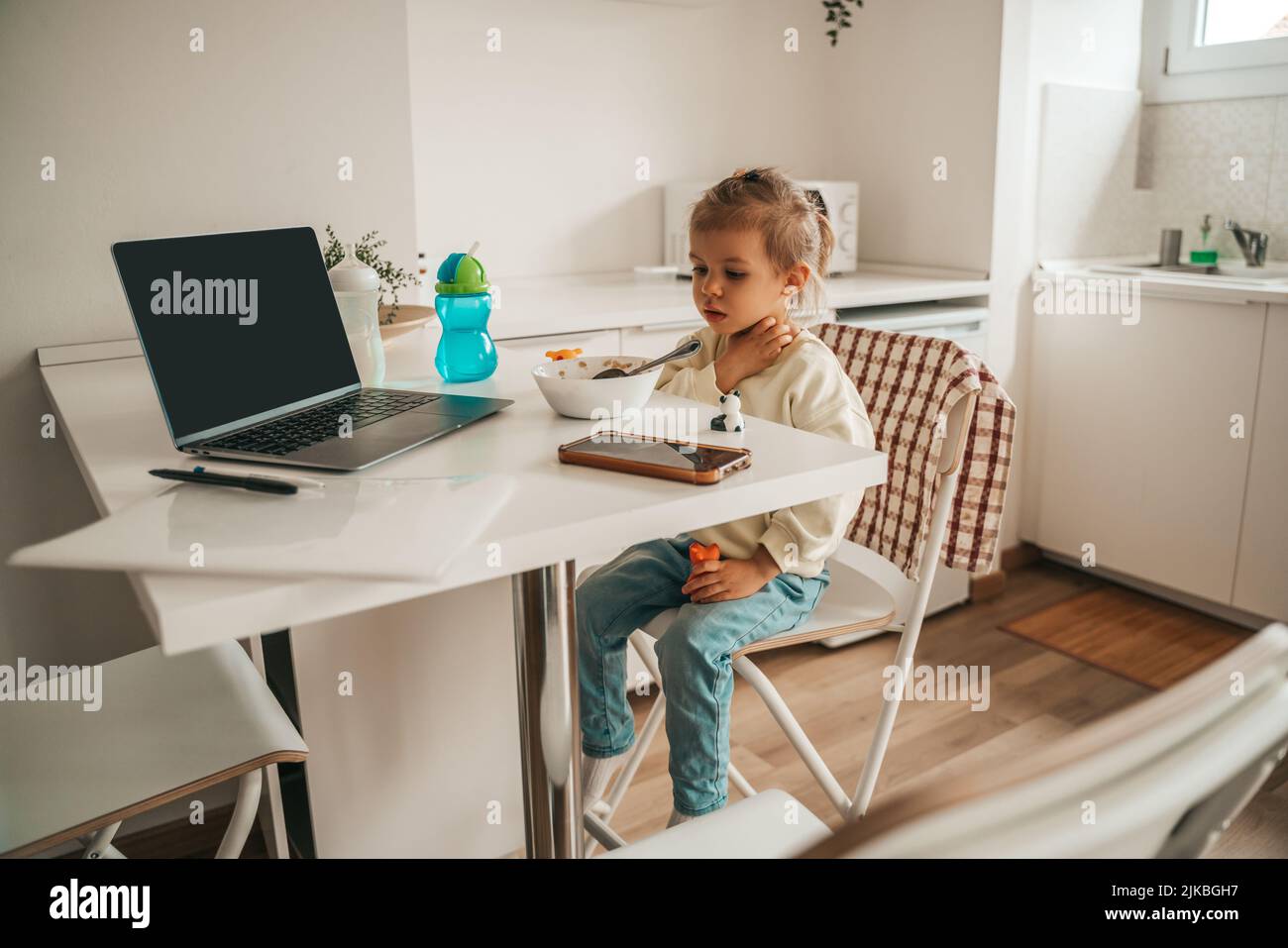 Thoughtful kid seated at breakfast in the kitchen Stock Photo - Alamy