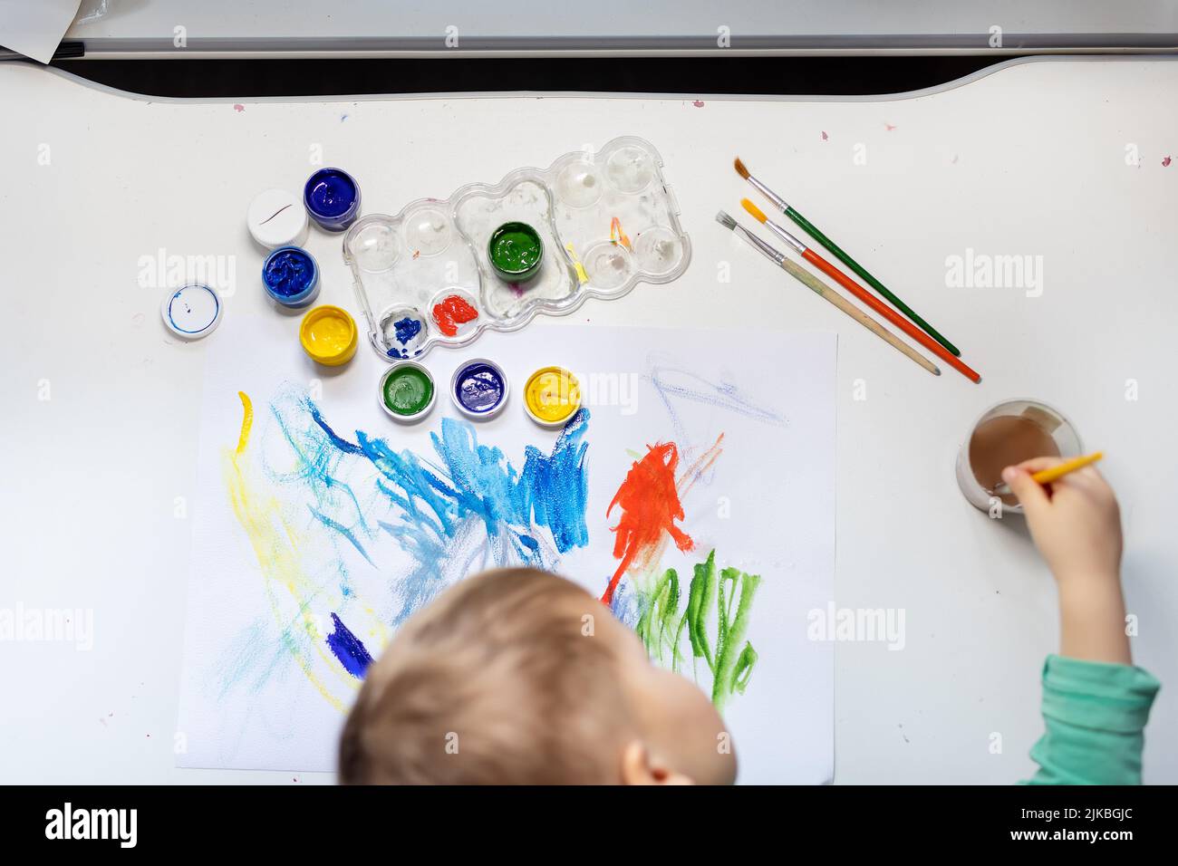 Top above view cute little blond kid boy enjoy have fun painting with ...