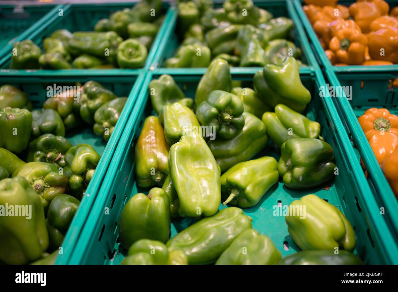 Raw juicy green bell pepper in plastic basket on the shelf in the ...