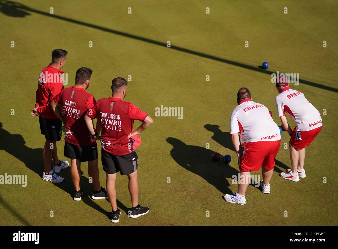 Players from Wales and England crowd around during the Men's Triples ...