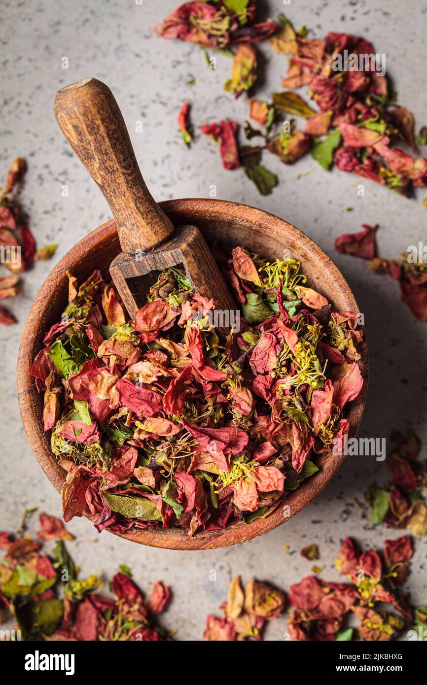 Dried quince flowers in a wooden bowl, closeup. Herbs of alternative ...