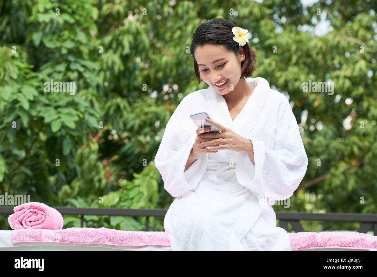 Spa salon client reading messages in her smartphone Stock Photo - Alamy
