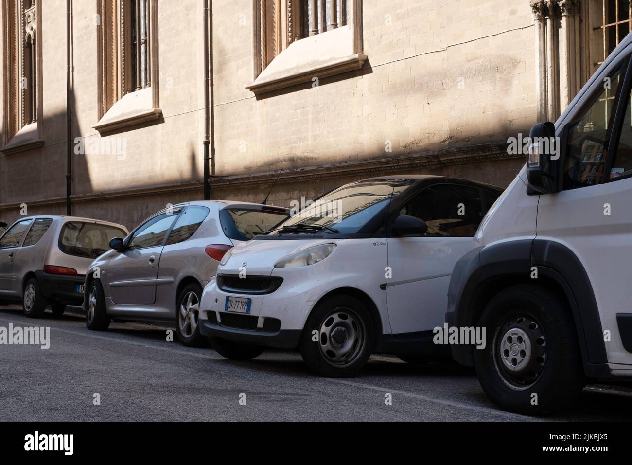 Smart car parked crosswise between other cars in Rome. Rome has the ...