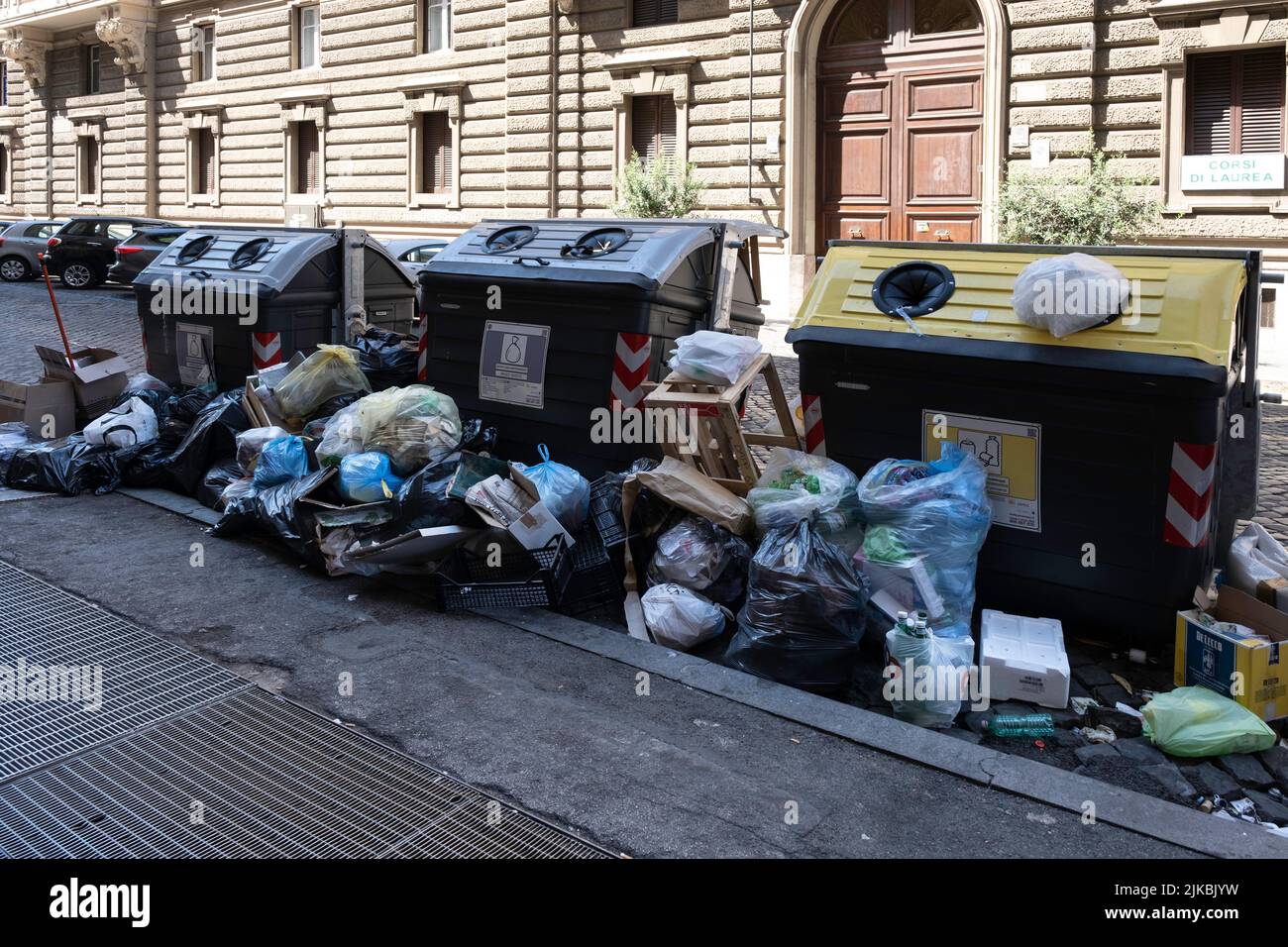 Overflowing dumpsters and garbage bags on the edge of a street in Rome ...