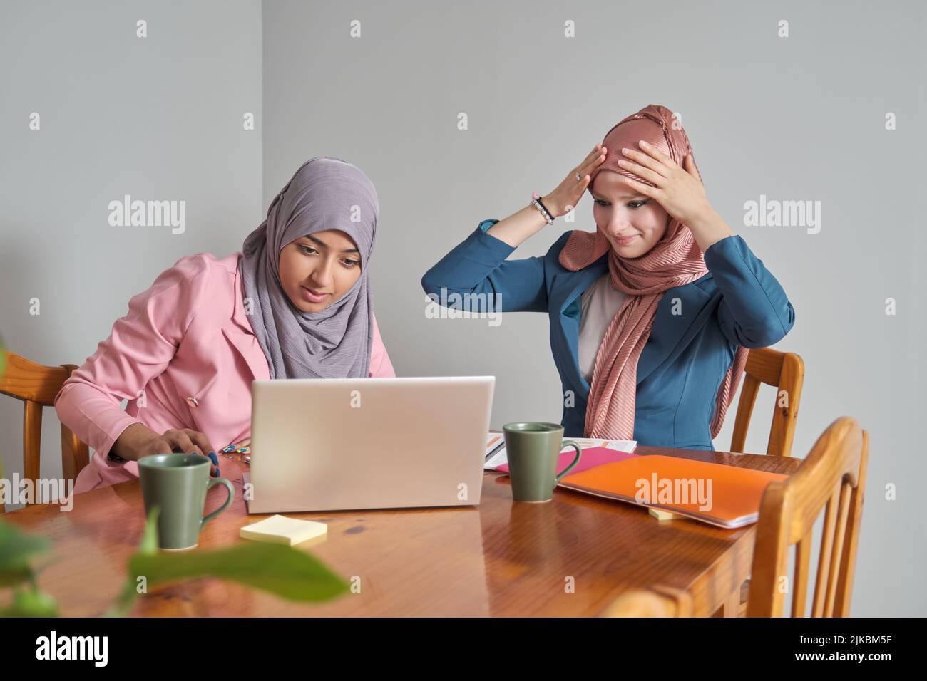 Two muslim female university students wearing hijab doing schoolwork ...