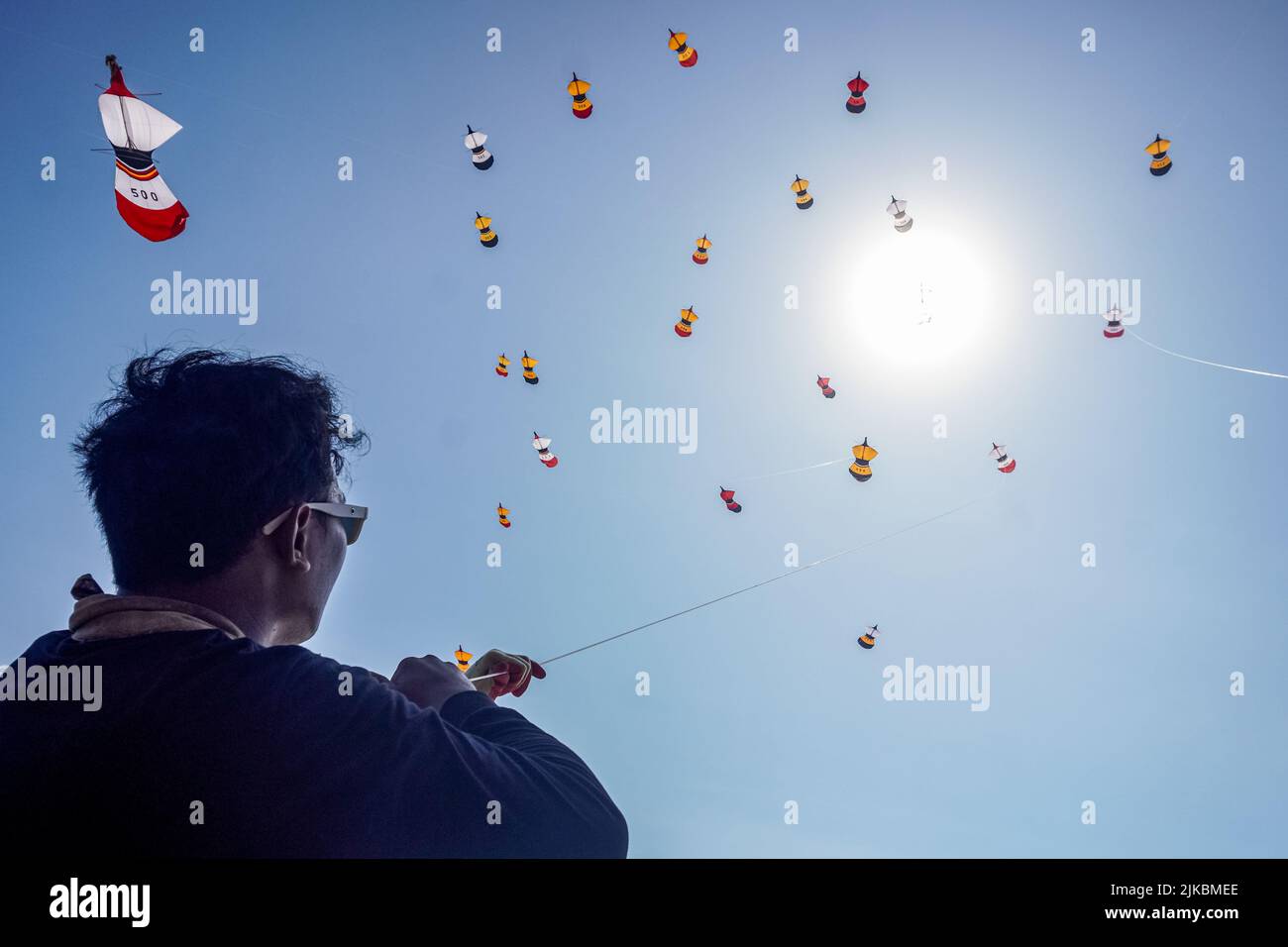 Denpasar, Indonesia. 31st July, 2022. A man seen drawing a kite string ...