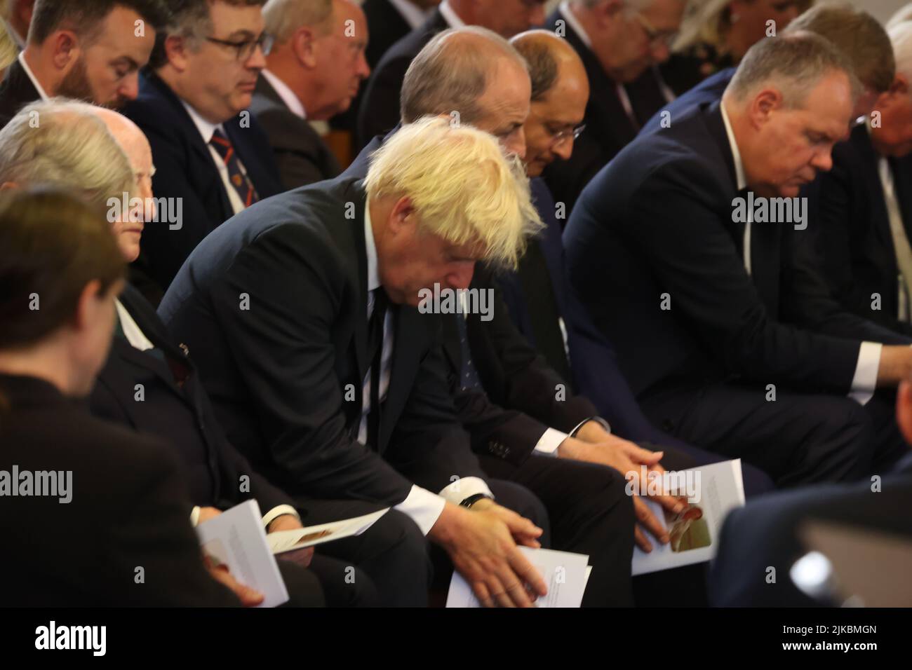 Mourners bow their heads in prayer at the funeral of former Northern ...