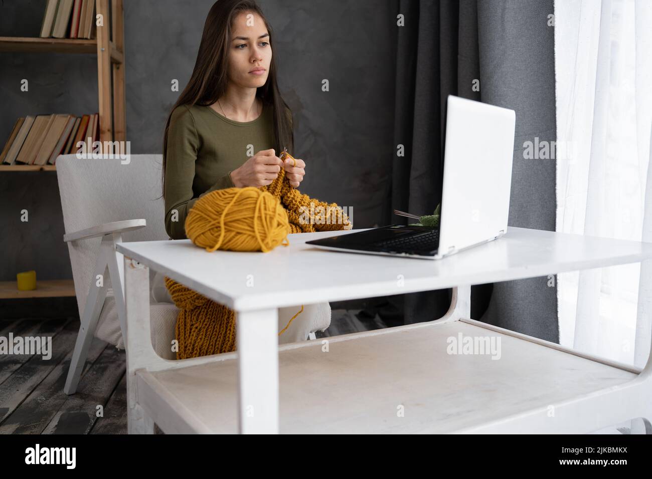 Seriously woman with knitting yarn and needles learn how to knit using ...