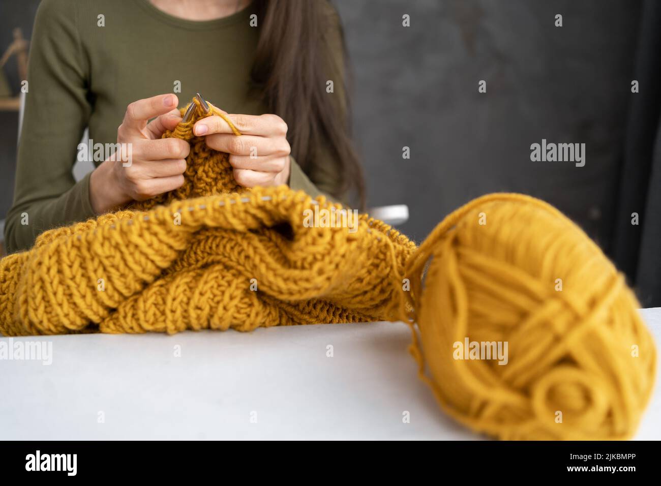 Close-up of female hands knitting wool sweater. Woman knits from thick ...