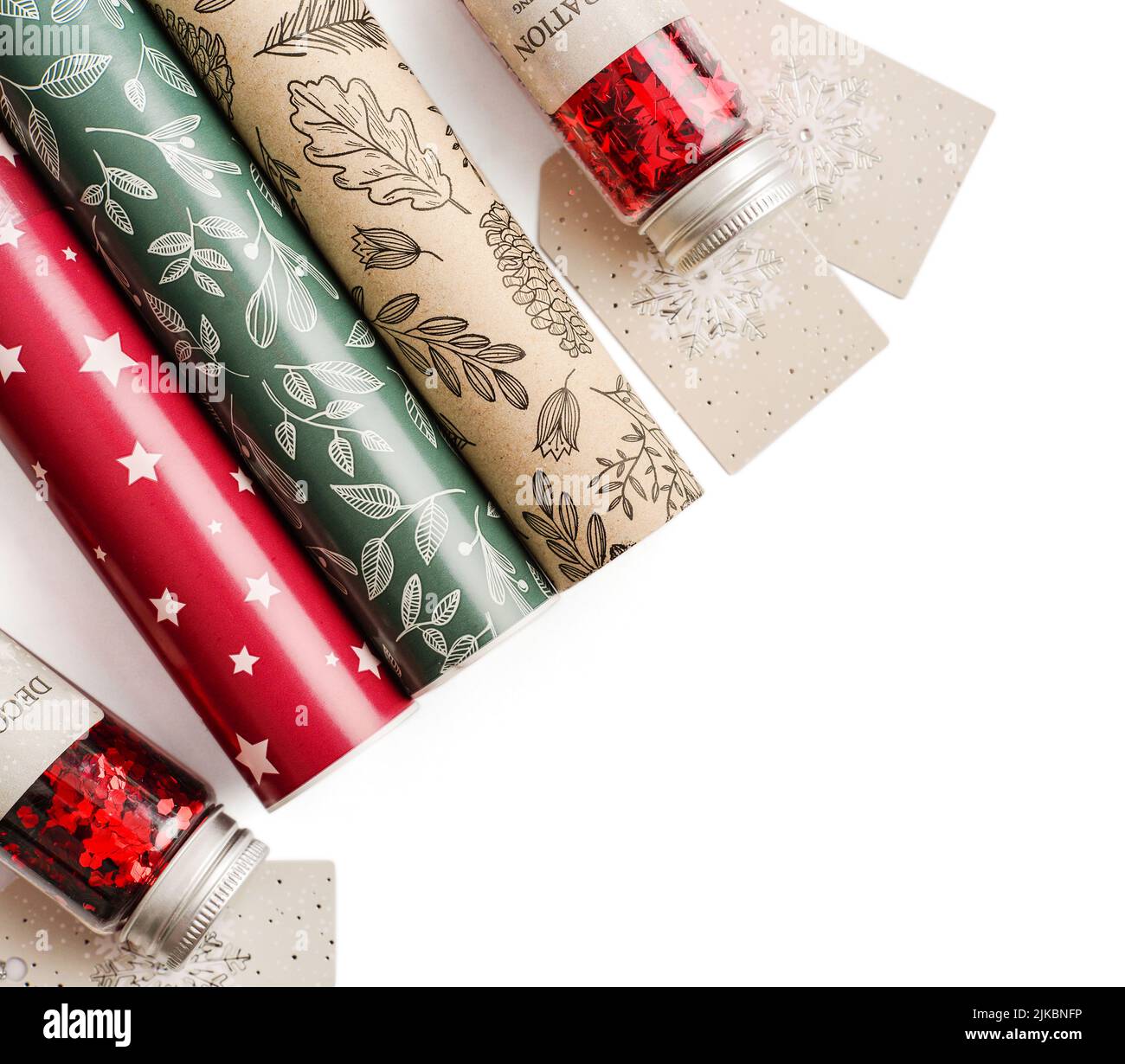 Rolls of colored wrapping paper with gift tags and sparkle red confetti ...