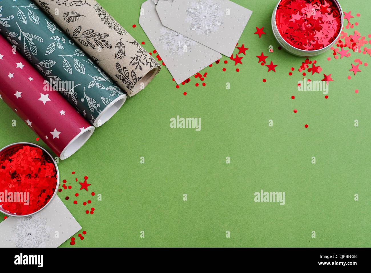 Rolls of colored wrapping paper with gift tags and sparkle red confetti ...