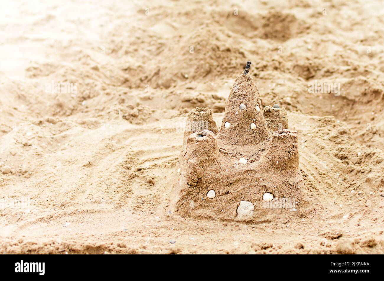 Sand castle and shells on the beach in the sun. Place for an ...
