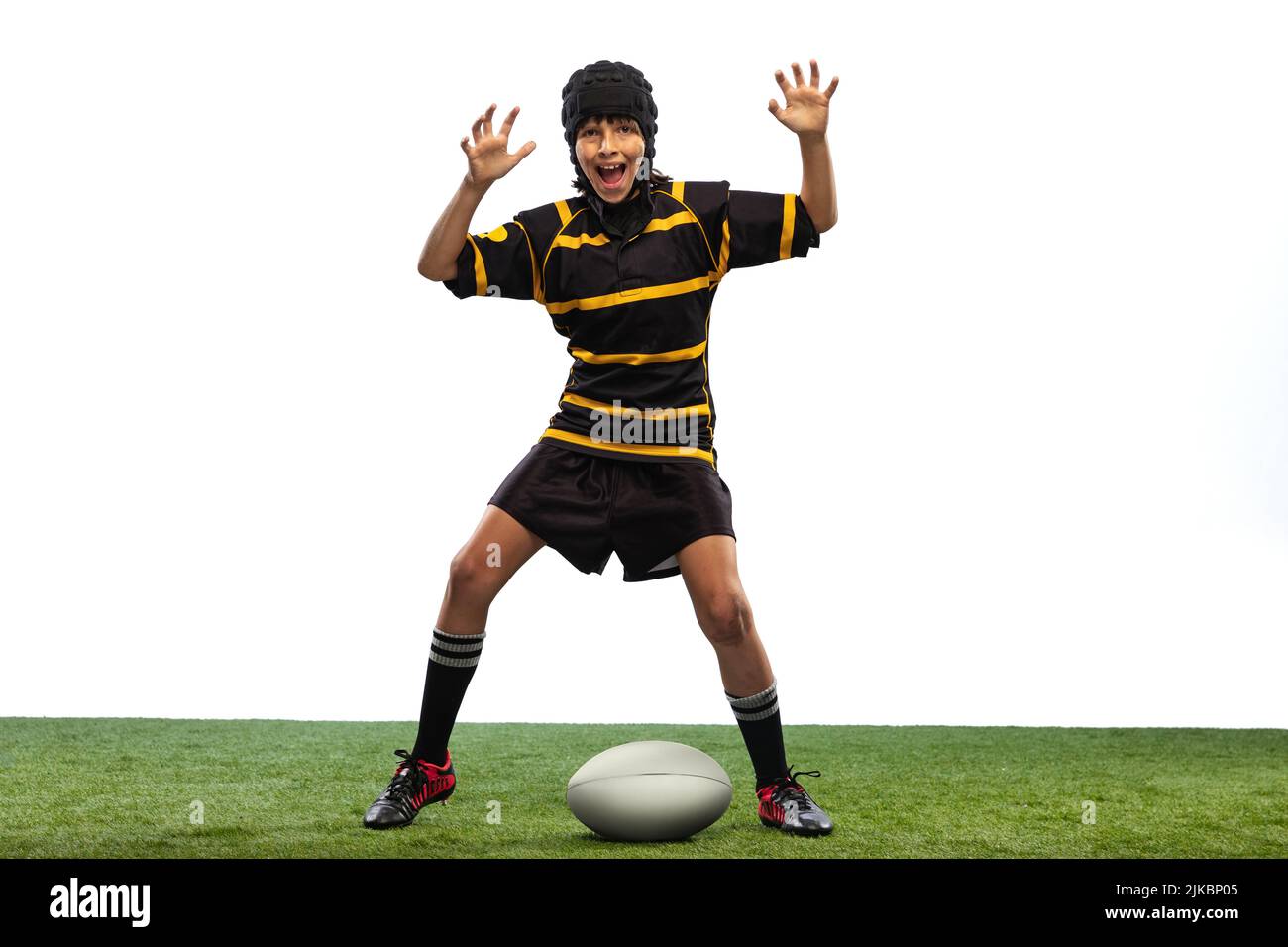 One sportive boy, kid, male rugby player training with ball isolated on ...